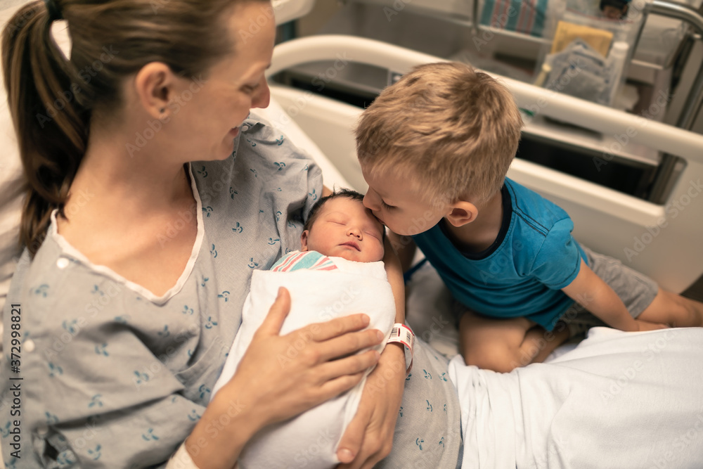 Photo Stock Brother welcoming a new baby sister to the family. Mother ...