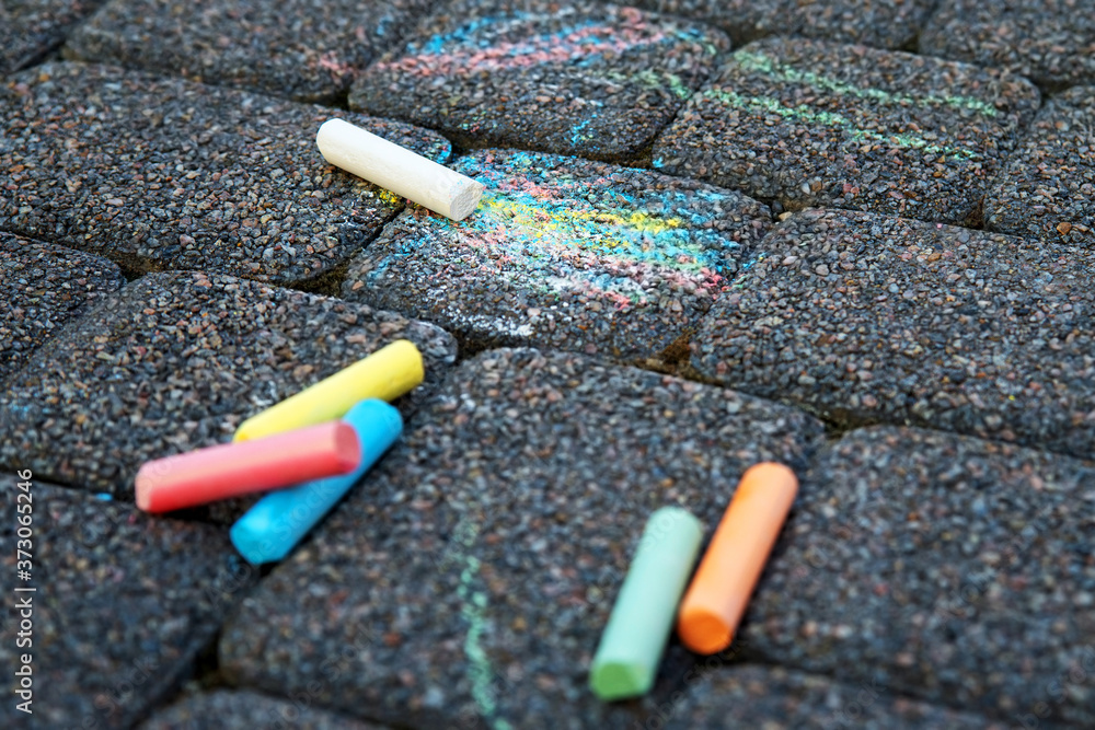 Colored chalk on playground with drawings on street.children drawing on ...