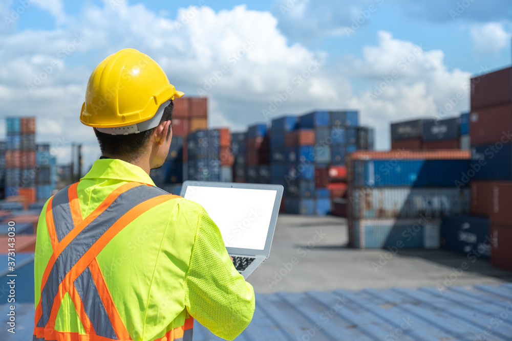 backview shipping worker or engineer using blank screen laptop in ...