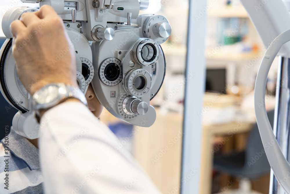 optometrists are examining pediatric patients' eyes with the ...