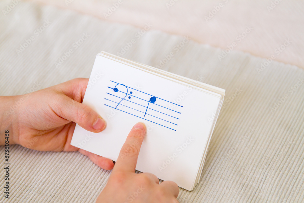 Young child practices naming music notes with flash cards; Young child ...