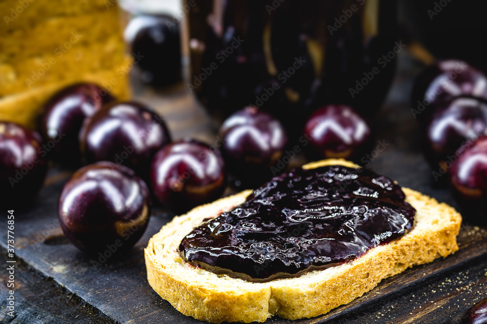 toast with grape jam, on rustic wooden table. Jabuticaba, exotic ...