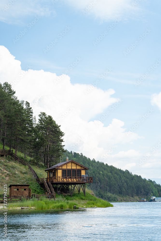 Small cute wooden hut on the share of Baikal lake with deep forest in ...