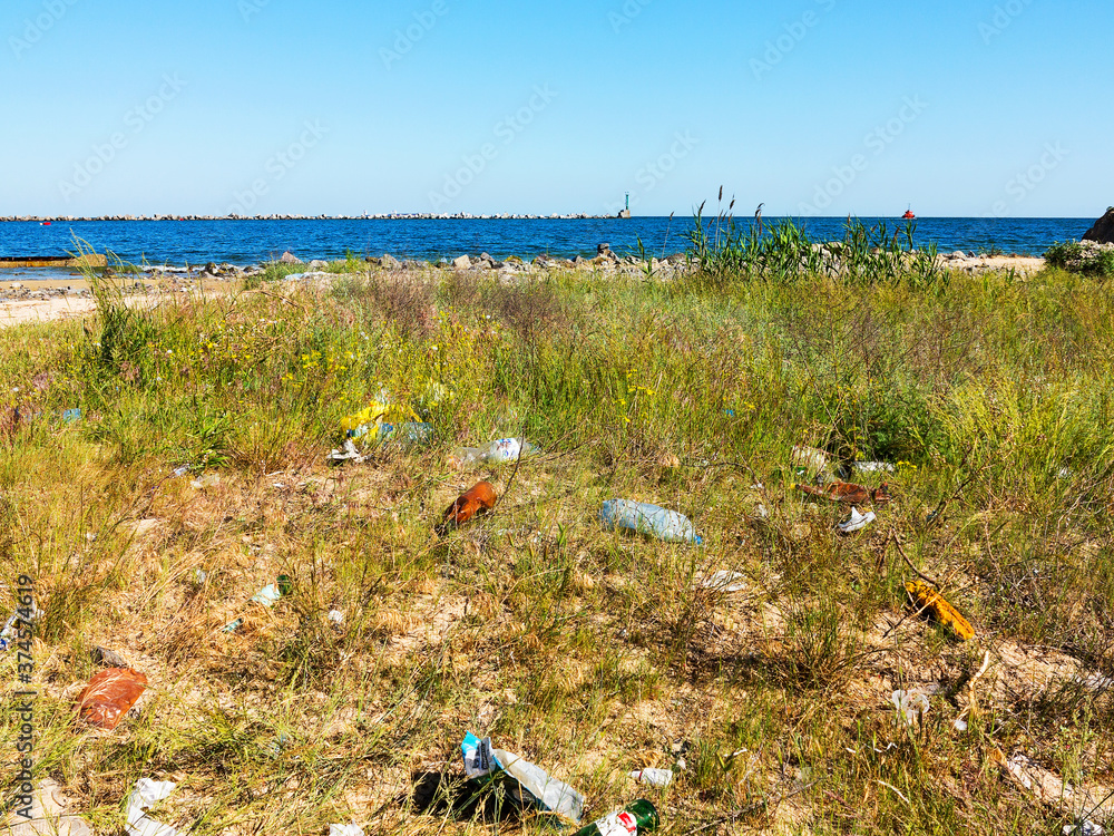 Lot of garbage and plastic bottles on the river shore. Environmental ...