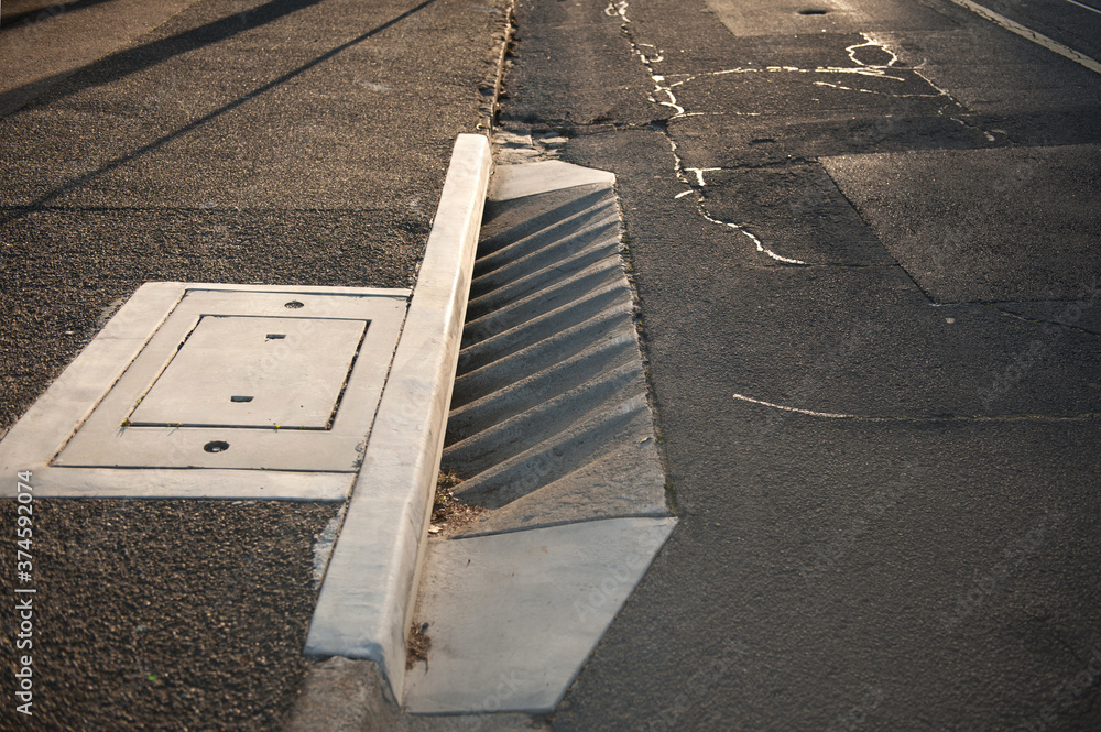 Gutter of a stormwater drainage system in perspective on the side of an ...