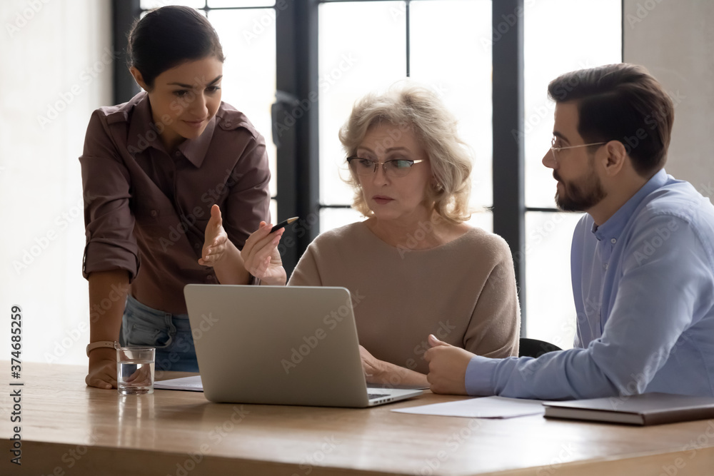 Focused middle aged 60s businesswoman discussing online project ...