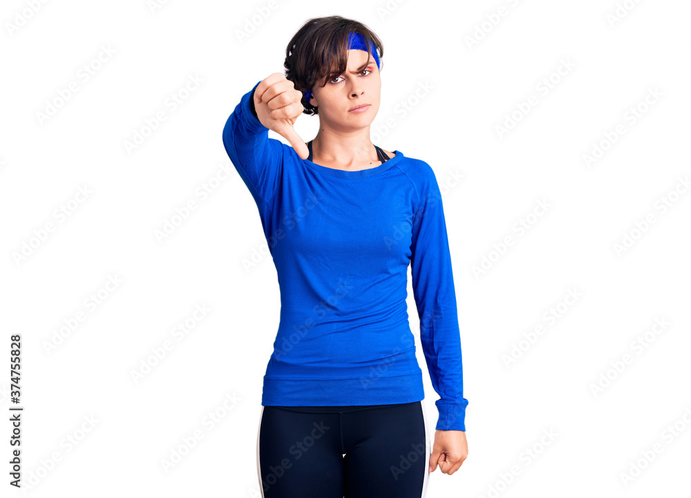 Beautiful young woman with short hair wearing training workout clothes ...