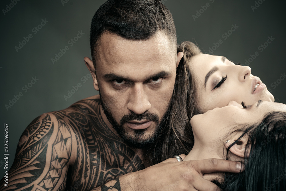 Sexual game and foreplay of three sexual partners. Two beautiful girls foreplay with handsome ...