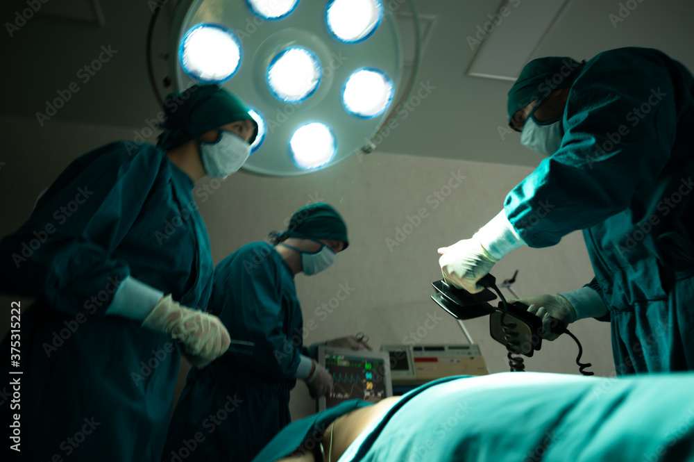 Medical team of surgeons in hospital doing invasive surgical ...