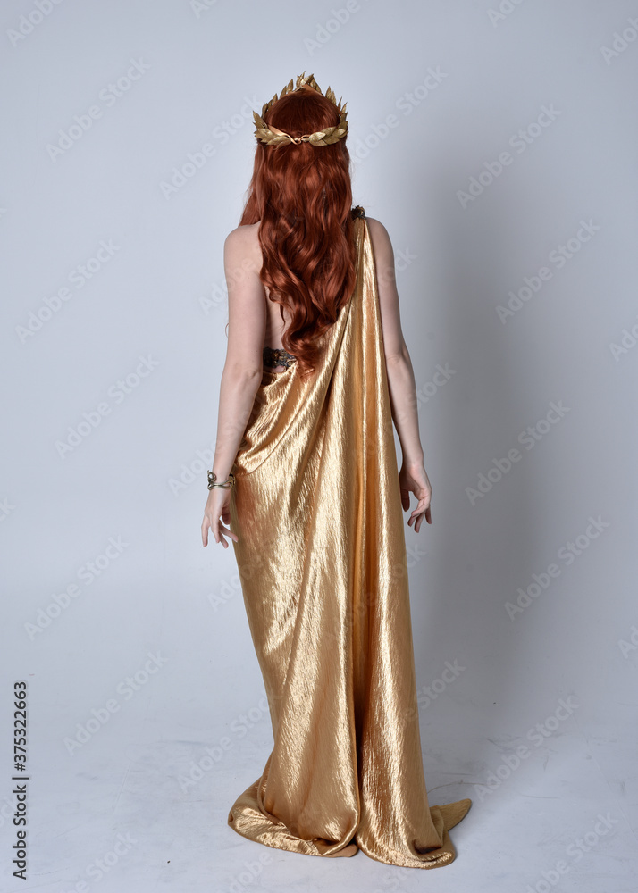 Full length portrait of girl with red hair wearing long grecian toga ...