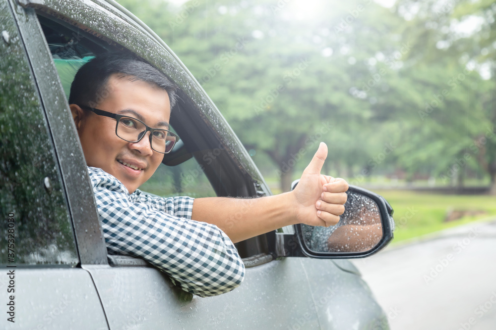 Smile people sitting in the car and thumbs up to camera. Happy driving ...