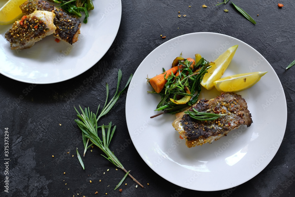 Grilled fish with lemon, herbs and rosemary. Fried fish fillets in a ...