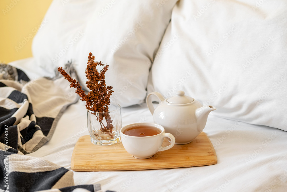 Tray of tea on bed. White bedding sheets with blanket and pillow ...