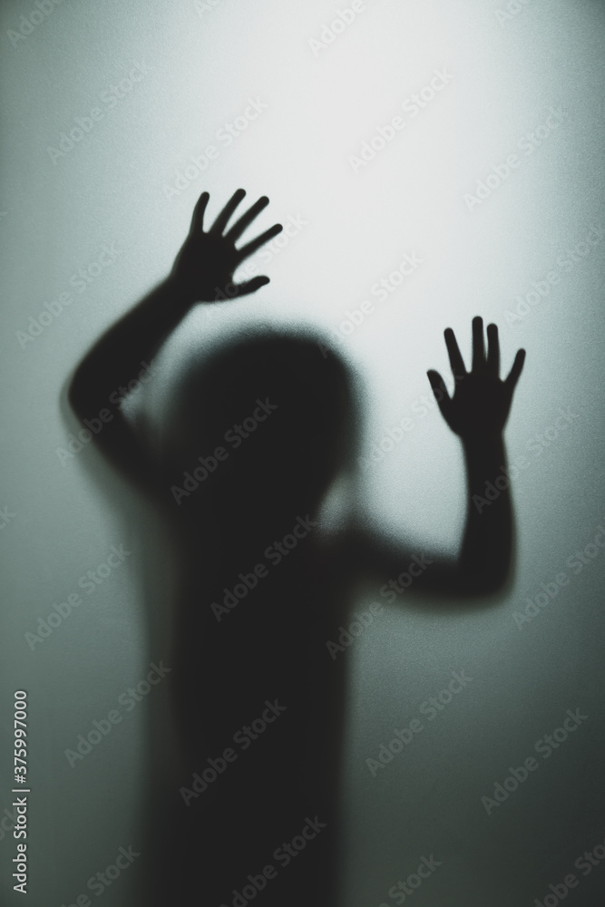 Ghost concept shadow of a child behind the matte glass blurry hand and ...