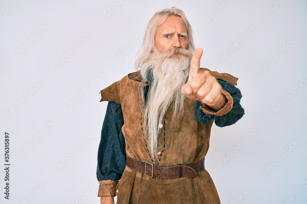 Old senior man with grey hair and long beard wearing viking traditional ...