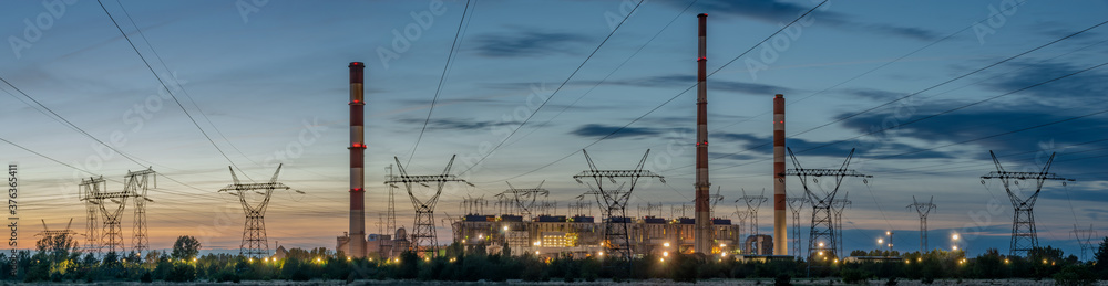 High-voltage pylons running straight from the power plant against the ...