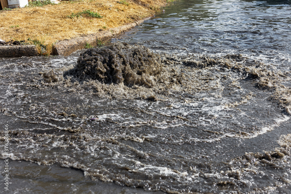 Water flows out of drainage hatch. Drainage fountain of sewage ...