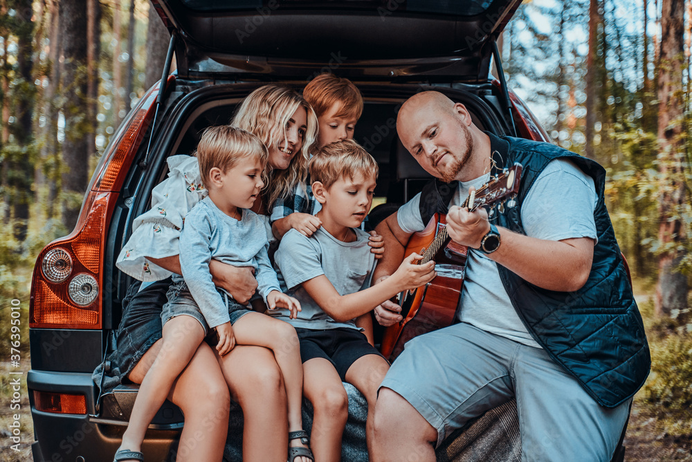 A family of musicians teaching their sons to play in guitar. American ...