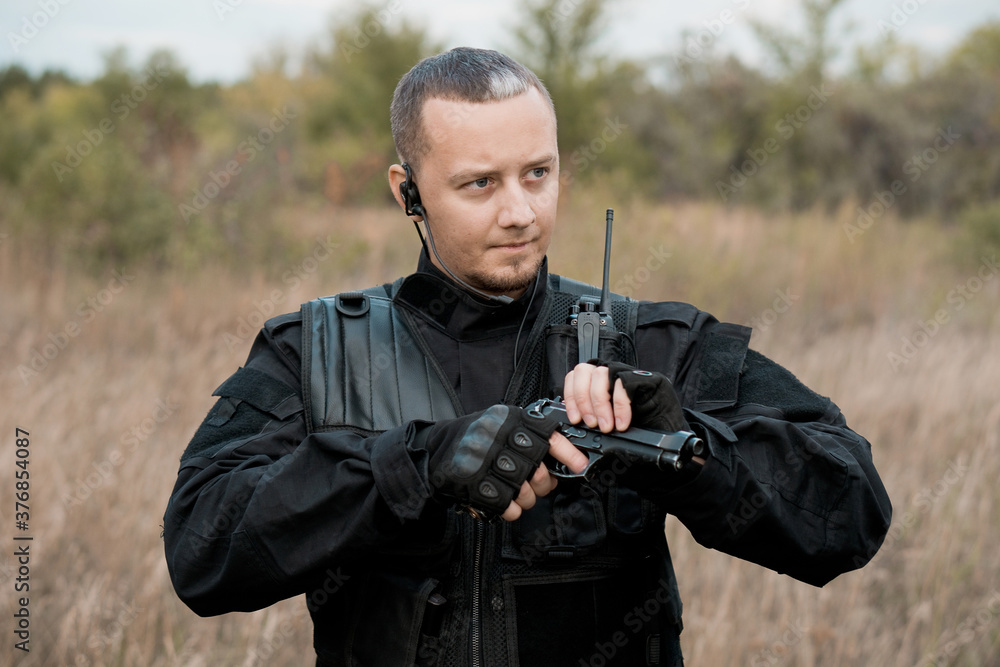 Special forces soldier in black uniform reloading a pistol. Stock Photo ...