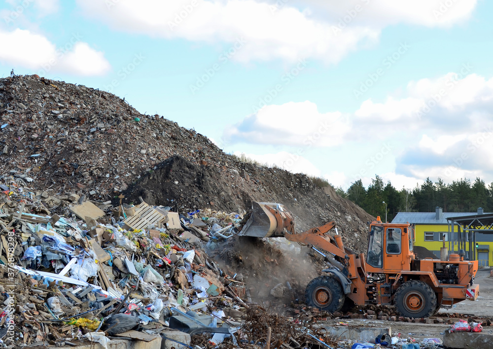 Front-end loader works in a landfill for the disposal of construction ...