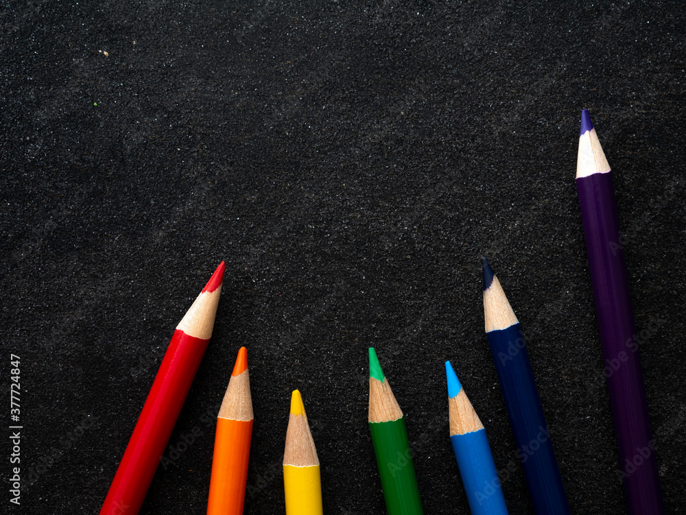 Bright colored pencils on a dark black background. Seven colors of the ...