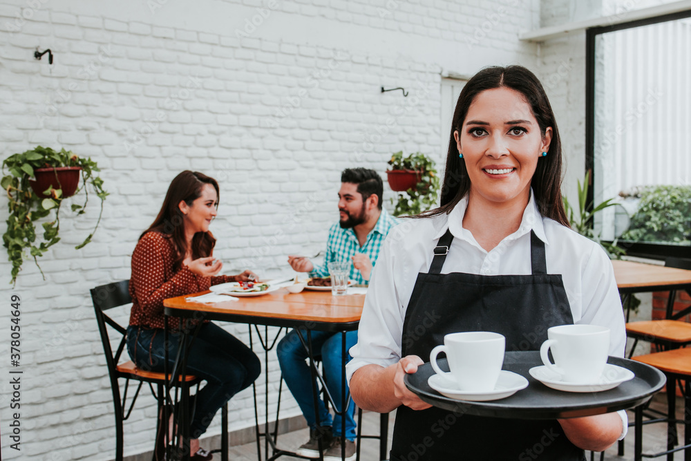 Owner mexican female waitress serving coffee to people sitting at ...