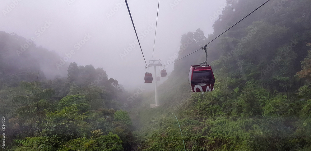 cable car at genting highlands, malaysia in a foggy weather with green ...