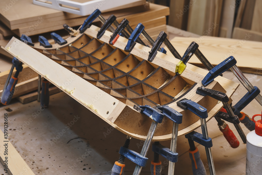 Joinery. Plywood bending process. Gluing and clamping bend wooden panel ...