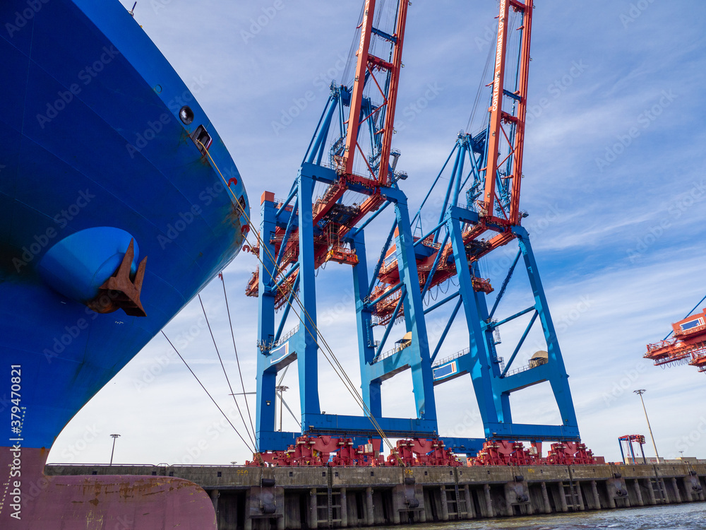 next to a container ship there are large container cranes for loading ...
