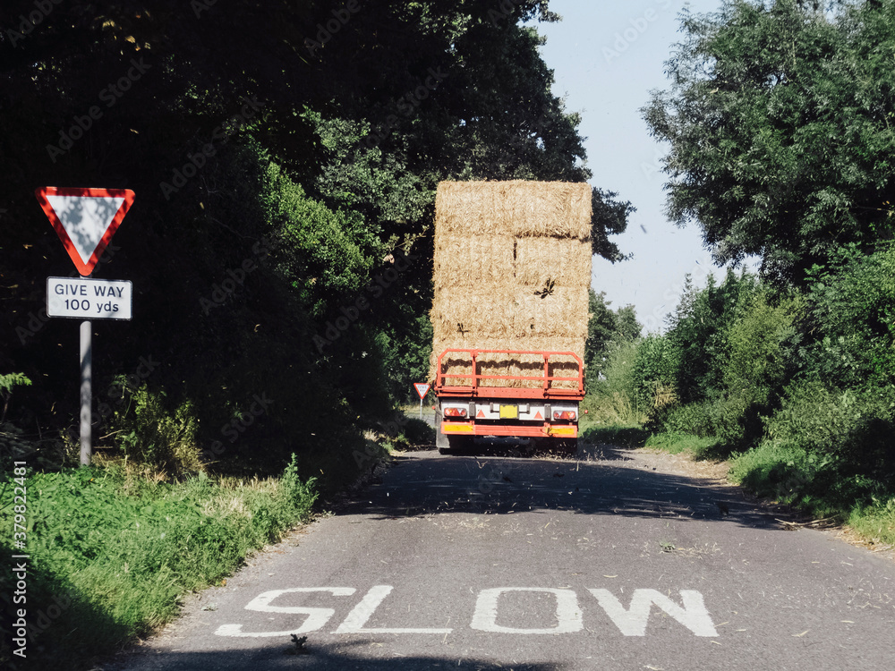 Slow sign and lorry transporting straw bales along a country roa Stock ...
