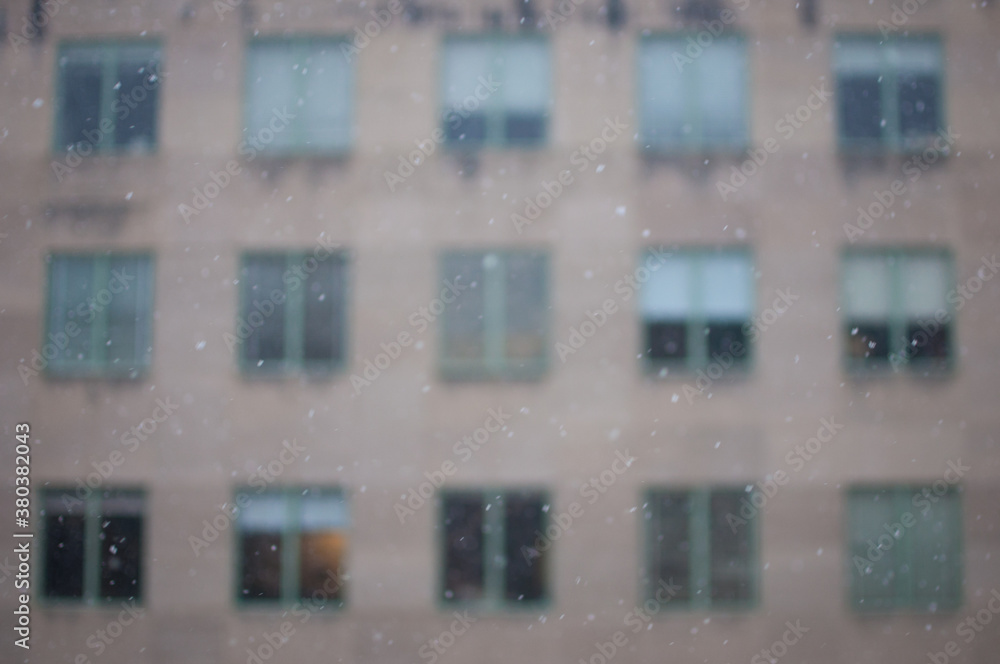 Snow falling in front of blurry building with lots of windows Stock ...