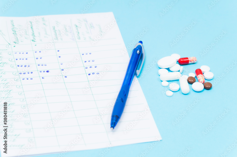 blue pen and tablets and medication schedule, concept of treatment ...