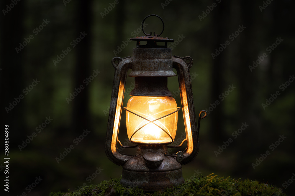 Old vintage lantern lit in the darkness close up. Blurred background ...
