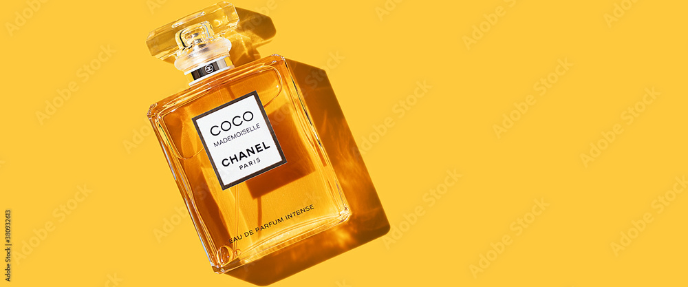 A bottle of Chanel perfume on a uniform yellow background, with a ...