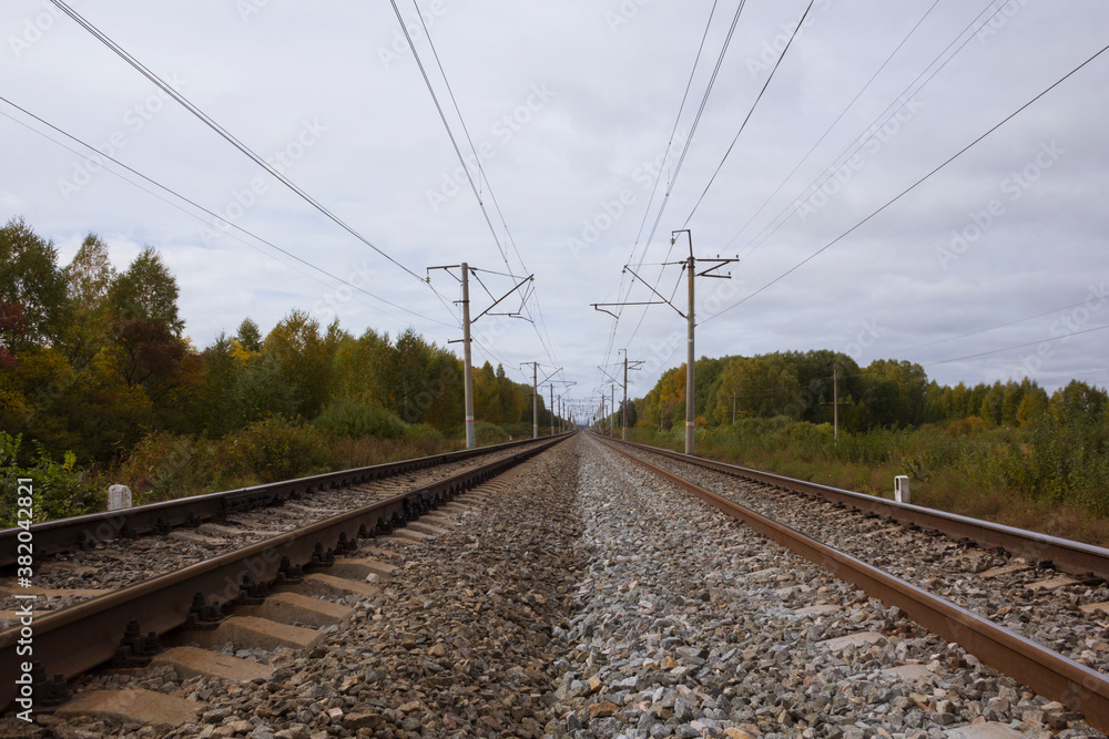 The double-track railway is straight as an arrow. Two paths and a ...