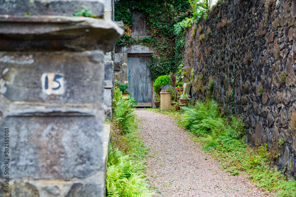 Alley with sand entrance, stone wall and wooden door at the end Stock ...