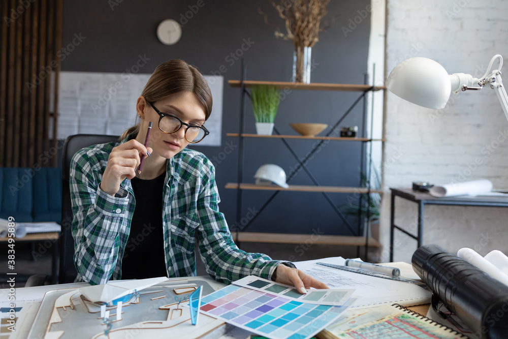 Female interior designer working in office with color palette ...