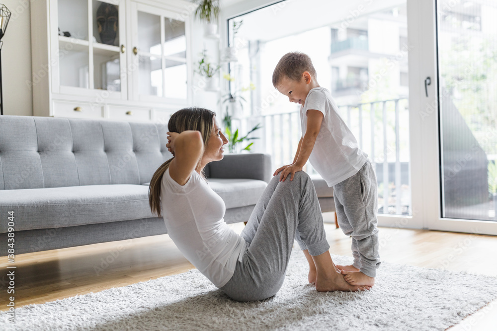 Mom with her son working out in the living room Stock Photo | Adobe Stock