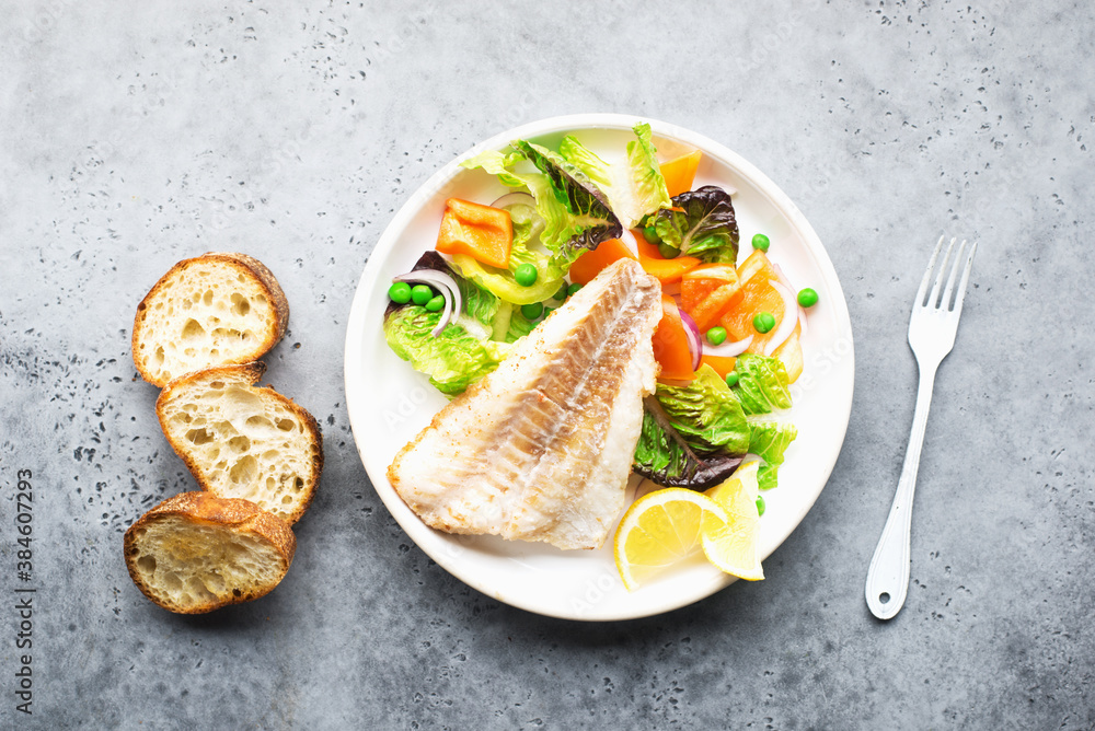 Fried fillet of sea white cod fish with juicy lettuce, capsicum, lemon ...