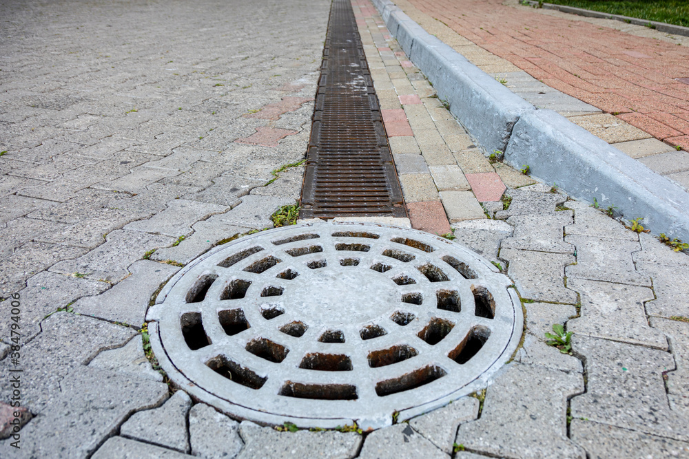 Modern street pavement made of paving stones and storm water drain ...
