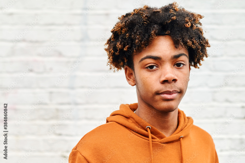 Teen boy standing alone outdoors Stock Photo | Adobe Stock