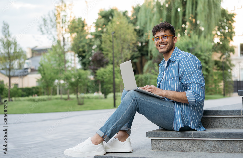 Portrait of happy Indian programmer using laptop computer, internet ...