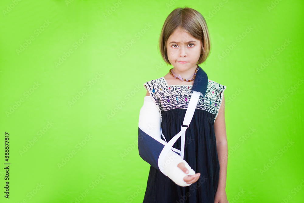 Niña lastimada con un yeso frente de una pared Stock Photo | Adobe Stock