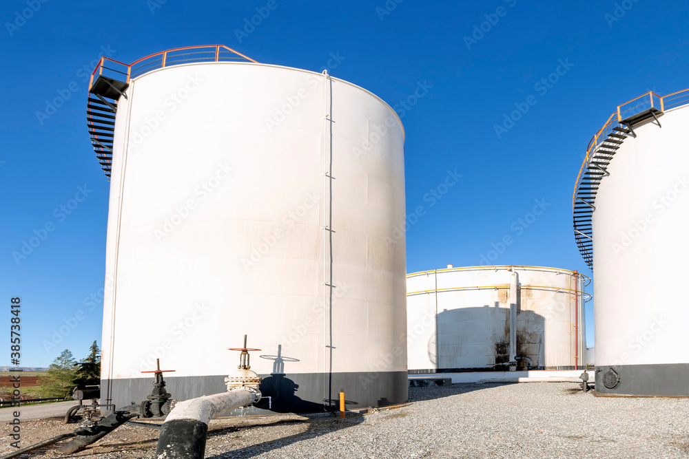 View of the cylindrical atmospheric fuel storage tanks with fixed roofs ...