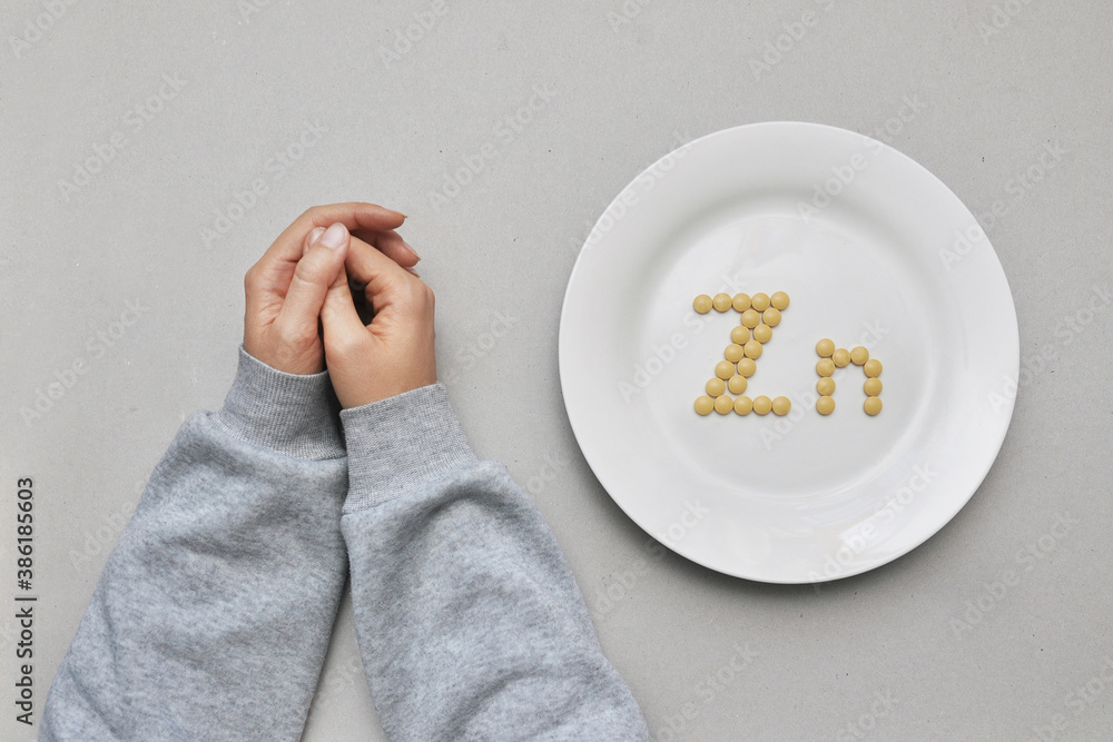 Sign of the trace element "zinc" from tablets on a white plate. Zinc ...
