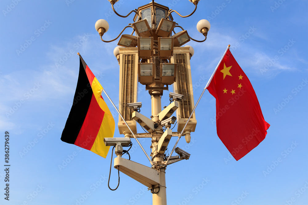 German and Chinese National flags flutter on a lamppost at Tiananmen ...