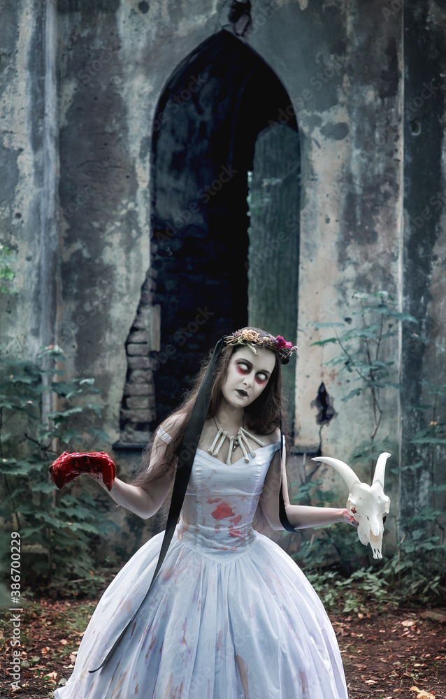 Creepy dead bride with bloody meat and goat skull standing in front of ...