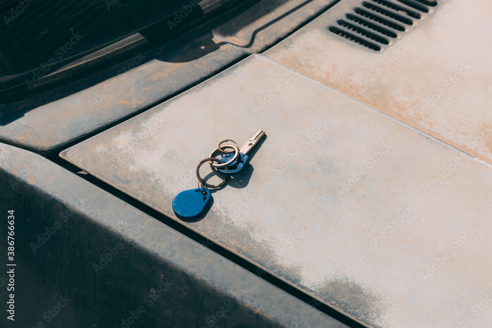 Lonely bunch of blue magnet keys on dirty old and rusting car, on the ...