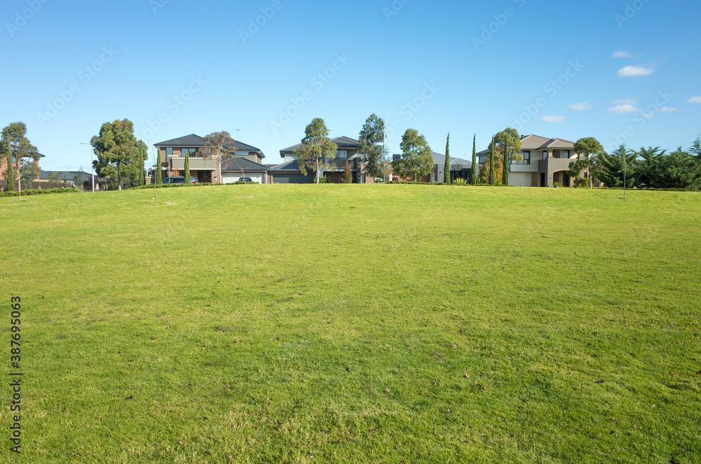 Background texture of green and healthy grass lawn with some two-story ...