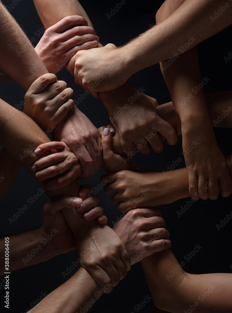 Forces. Hands of people's crows in touch isolated on black studio ...